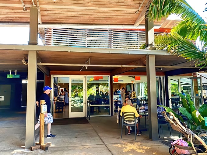 The welcoming entrance to Fogg Café beckons garden explorers with its modern design and promise of culinary delights amid tropical splendor.