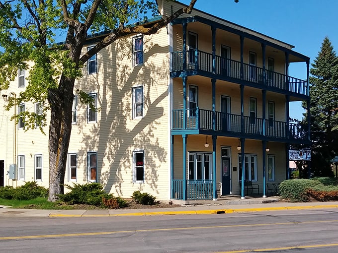 The Thayer Hotel's butter-yellow exterior with blue trim looks like a Victorian dollhouse that grew up and got a liquor license.