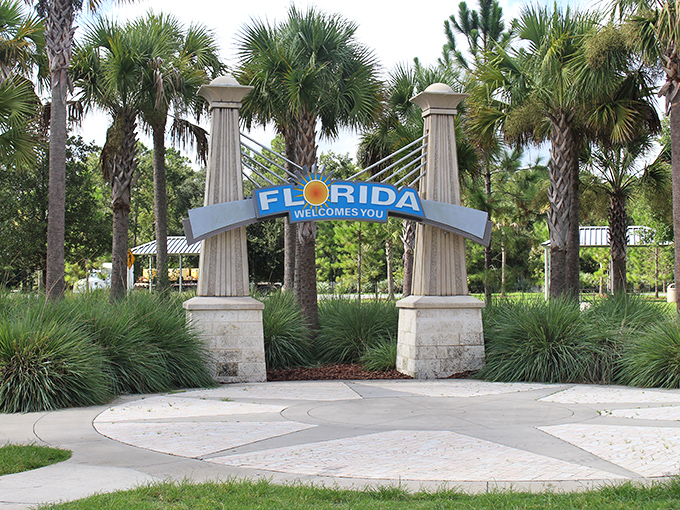 The iconic Florida Welcome Sign stands like a sunlit promise between those majestic columns. Vacation officially begins here!