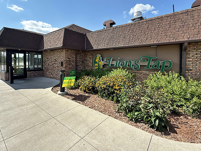 The unassuming exterior of Lion's Tap belies the burger magic happening inside. Yellow sign, brick building, and decades of delicious history.