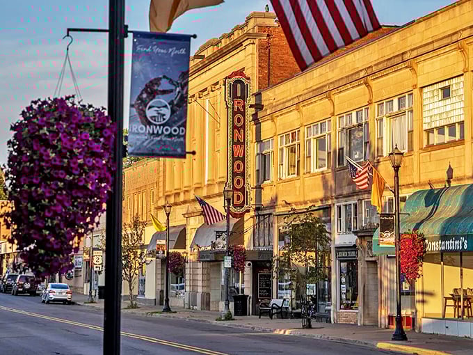 Ironwood's historic downtown glows golden in evening light, where hanging flower baskets and American flags create a timeless Main Street postcard come to life.