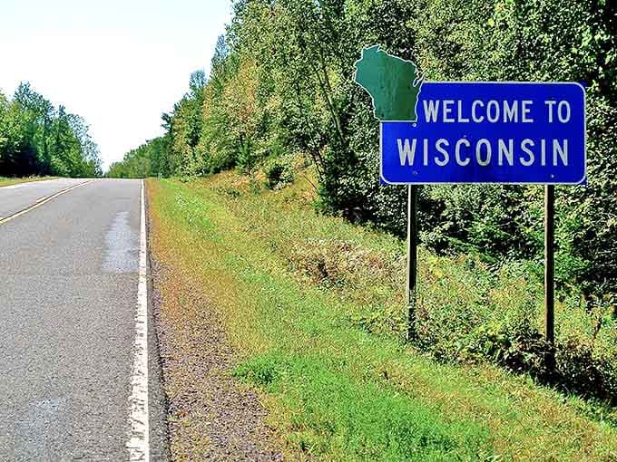 The iconic blue "Welcome to Wisconsin" sign stands sentinel on a quiet highway, promising adventures beyond the asphalt ribbon.