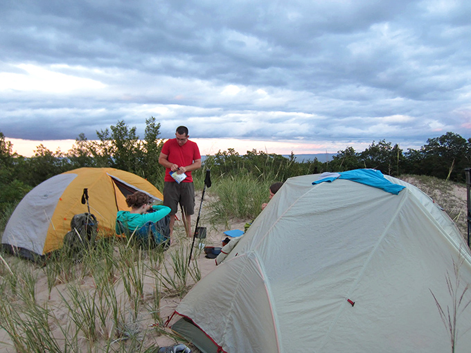 Twilight transforms ordinary campers into silhouetted adventurers against nature's most spectacular light show.