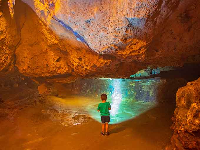 This kid stands mesmerized by the underground pool, probably wondering if it counts as a natural swimming hole.