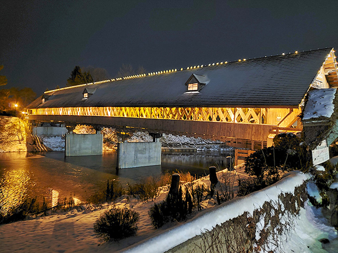 The bridge's nighttime glow reflects in the water below, doubling the visual impact and creating a moment of pure Michigan magic worth braving the cold.