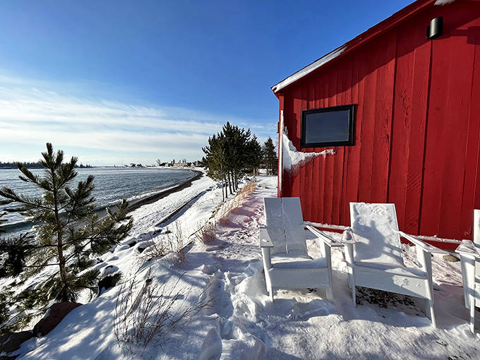 Winter transforms the shoreline sauna experience into a snow-globe scene, with white chairs waiting patiently for braver souls.
