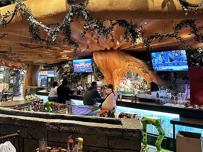 The bar area, carved from what appears to be a massive tree trunk, serves up cocktails with names as wild as the decor.