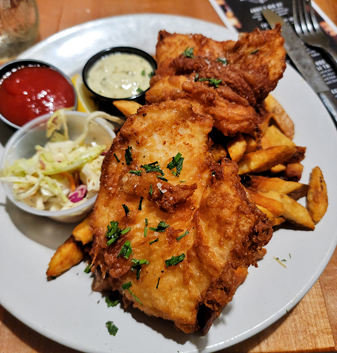Beer-battered haddock that shatters delicately with each bite, revealing steaming, flaky fish that makes you reconsider every other fish and chips you've had.