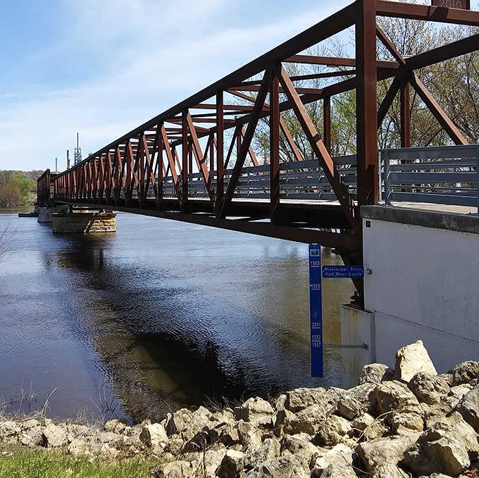 Beneath the sturdy framework, the Mississippi continues its ancient journey, a constant reminder of nature's patient persistence.