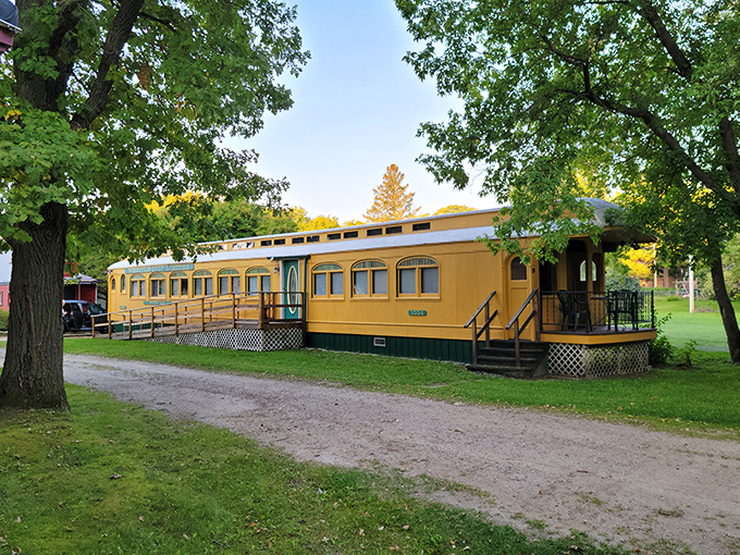Stone pathways connect the various train cars, creating a journey between journeys across the carefully maintained grounds.