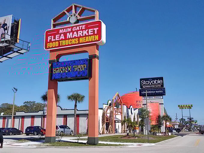 Main Gate's distinctive entrance stands like a carnival midway in Kissimmee's tourist corridor, promising vacation treasures at bargain prices.