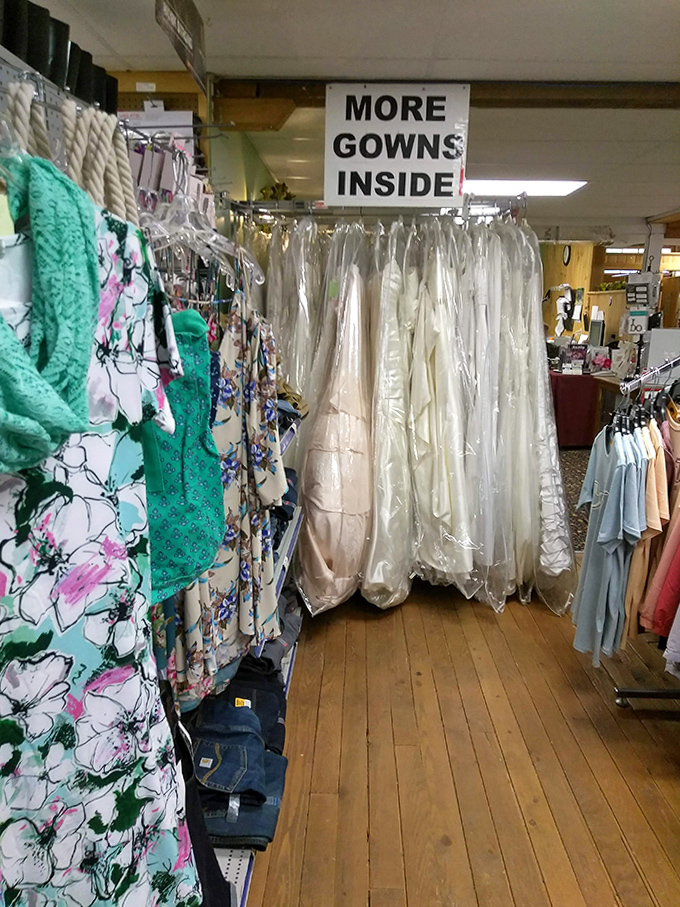Wedding dreams hang in pristine white rows, patiently waiting for brides who probably didn't expect to find "the one" between hardware and hunting gear.