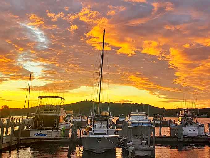 Sunset transforms Elberta's harbor into a dreamscape, where boats silhouetted against the fiery sky seem to float between worlds.