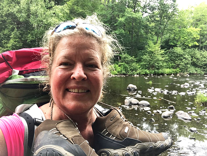 A hiker pauses to soak in the moment, surrounded by the soothing sounds of flowing water and forest whispers.