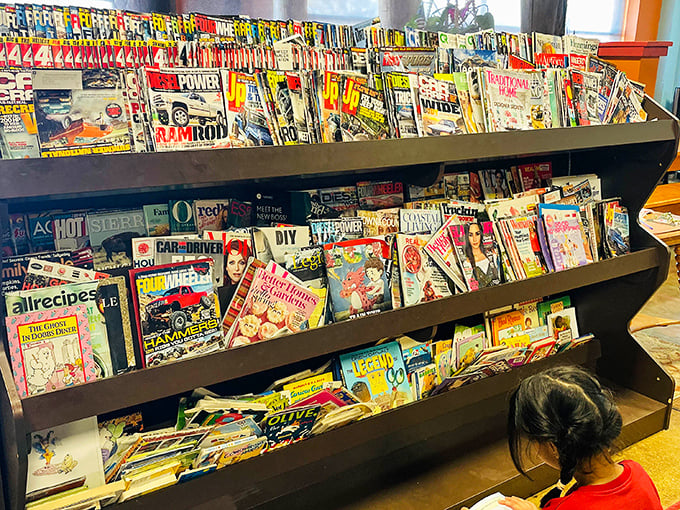 Magazine racks filled with reading material for all ages – because sometimes parents need five minutes with words not found in picture books.