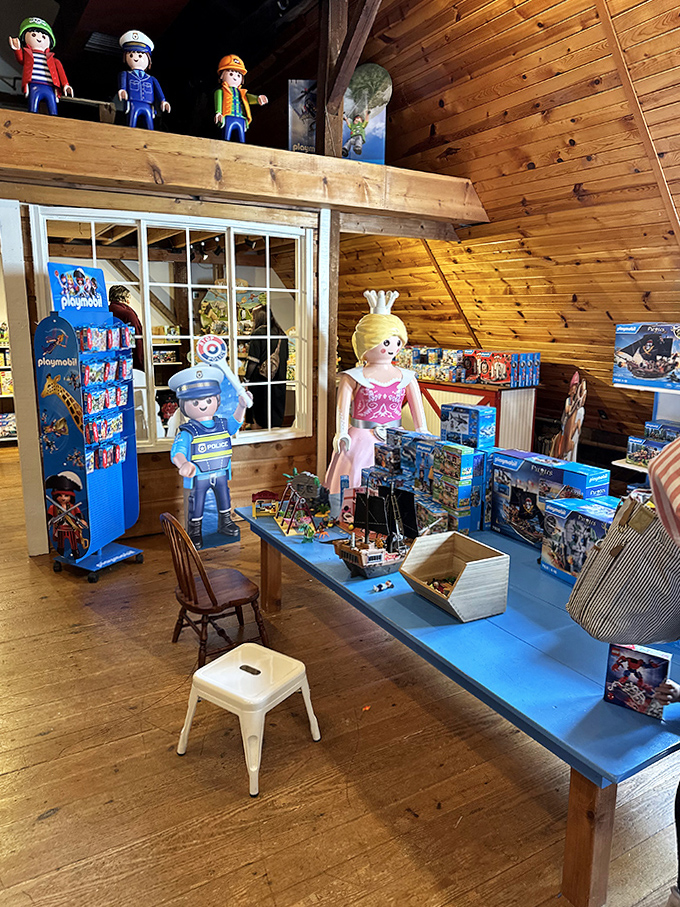 Playmobil Display Table: Life-sized figures stand guard over miniature worlds, creating a surreal playground where imagination knows no scale.