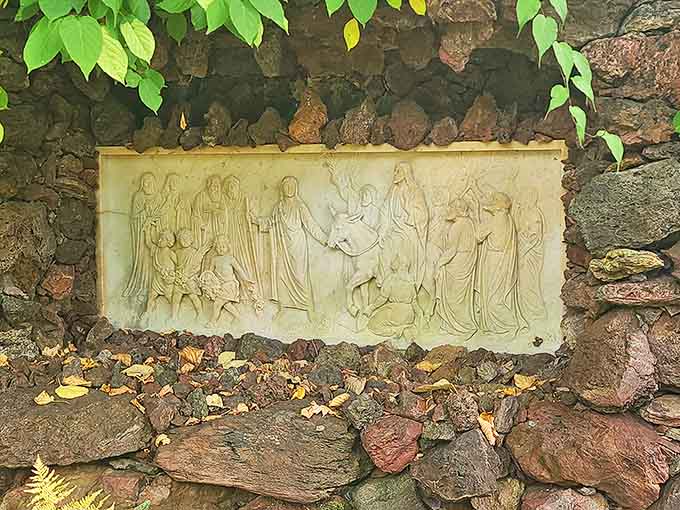Religious art nestled within stone walls creates unexpected moments of beauty and contemplation throughout the garden journey.