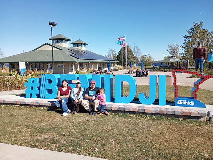 Families create memories at the #BEMIDJI sign, a modern tradition alongside the classic statues that have welcomed generations.