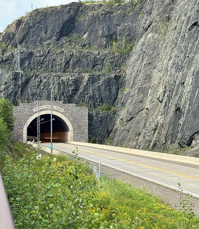 Fall colors frame the tunnel entrance, creating a seasonal portrait that highlights both natural beauty and engineering achievement in perfect harmony.