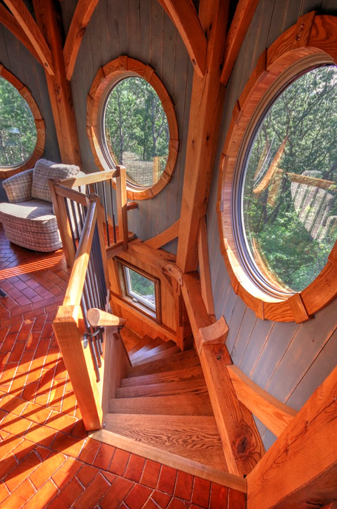 Spiral stairs lead upward through circular windows that frame the forest like living paintings &ndash; each step reveals new vistas.