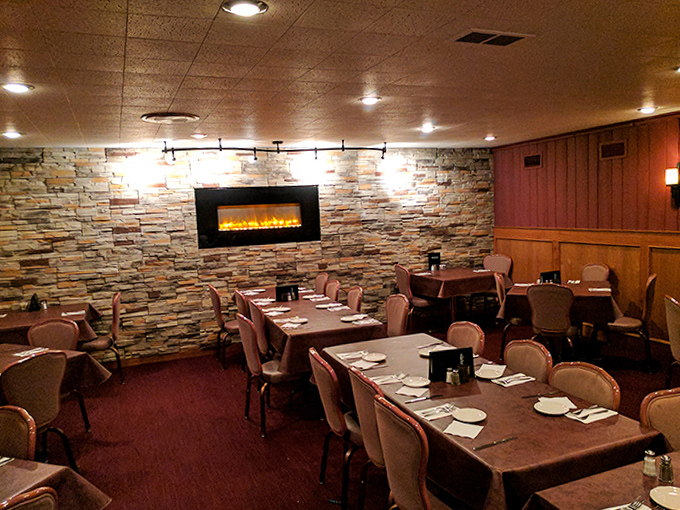 The dining area's stone wall and electric fireplace create a cozy backdrop for conversations that flow as easily as the cocktails.