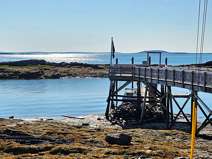 Wooden pier stretches toward the sparkling horizon, inviting visitors to pause and soak in Bailey Island's coastal beauty.
