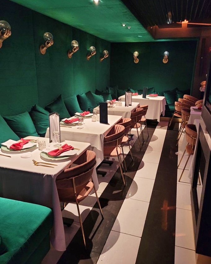 Modern chandeliers cast a golden glow over diners &ndash; even the ceiling knows how to make an entrance.