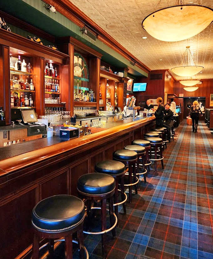 The bar stretches invitingly with its rich wood and plaid carpet &ndash; a place where strangers become friends and friends become family over perfectly mixed cocktails.
