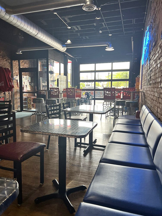 Dining area bathed in natural light, where metal tabletops gleam and that inviting blue banquette practically begs you to linger past lunchtime.