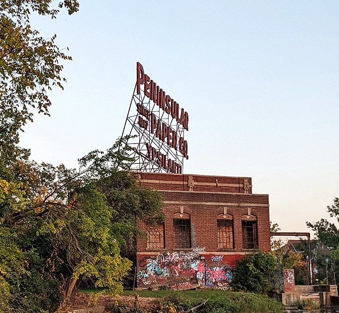 The iconic Peninsular Paper Company sign stands as a weathered sentinel, reminding visitors of Ypsilanti's industrial heritage.