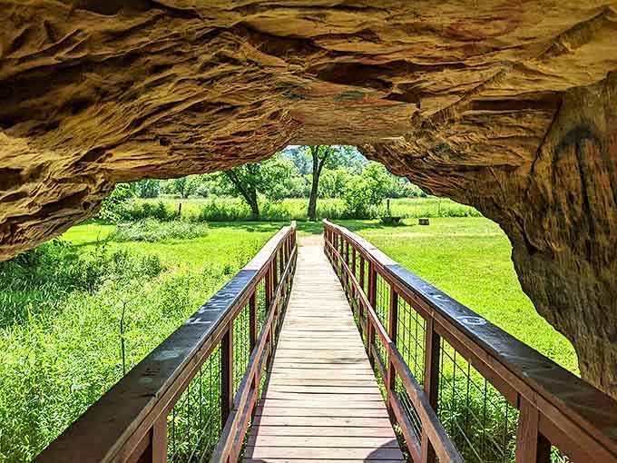 The iconic red footbridge guides visitors through nature's cathedral, where sunlight plays through stone openings like stained glass.