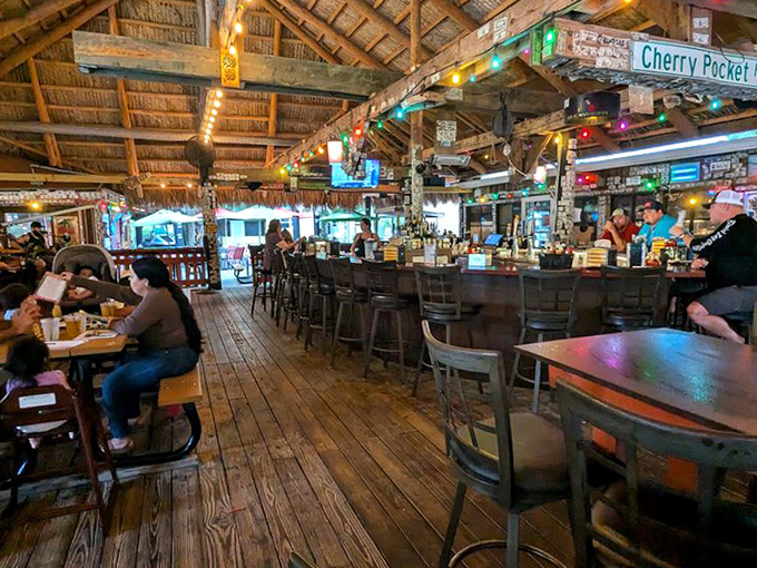 The bar area buzzes with energy as locals and visitors alike gather for cold drinks, hot food, and the kind of conversations you can only have at a true Florida fish camp.