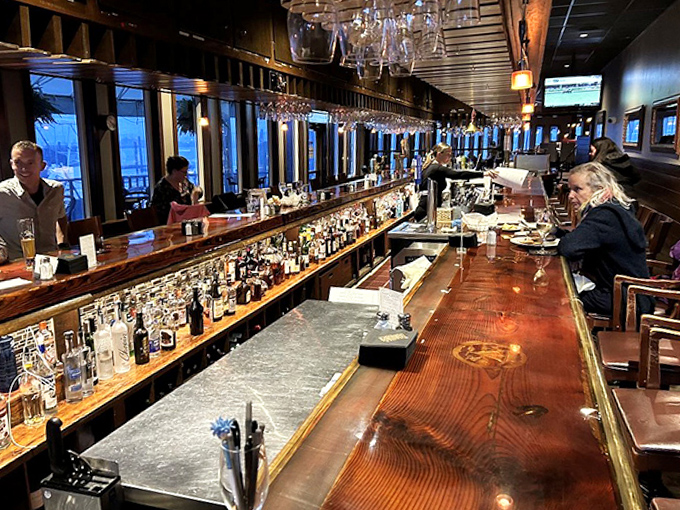 The bar stretches like a wooden masterpiece, backed by an impressive array of spirits that would make any sailor forget about basic rum rations.