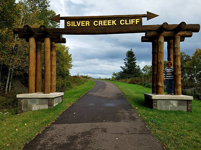 The wooden gateway to the Gitchi-Gami Trail invites adventurers to experience the old highway route on foot, where cars once precariously hugged the cliff edge.