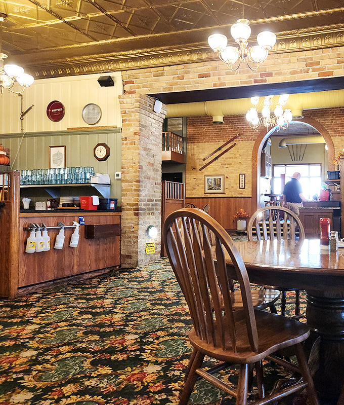 Windsor chairs gather around tables where generations have celebrated, commiserated, and savored life's moments beneath ornate tin ceilings and brick walls.