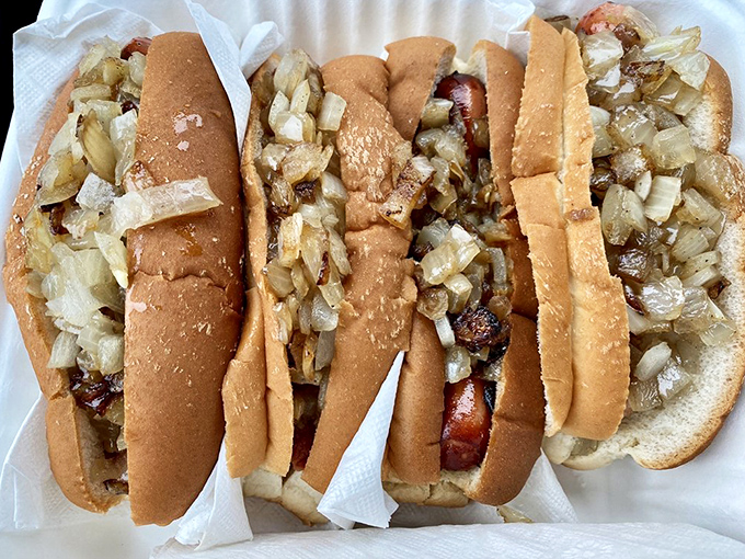The classic loaded dogs with grilled onions &ndash; a masterclass in how simple ingredients, properly prepared, create food memories that last a lifetime.