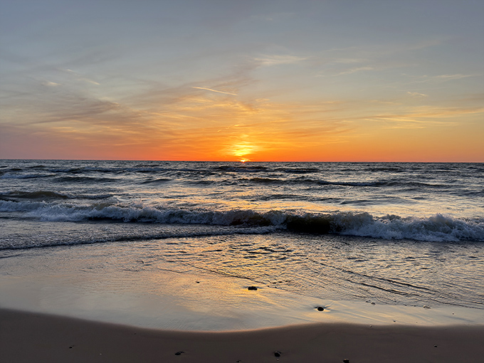 The grand finale of daylight creates a canvas of fire and gold, silhouetting beachcombers against nature's nightly masterpiece.