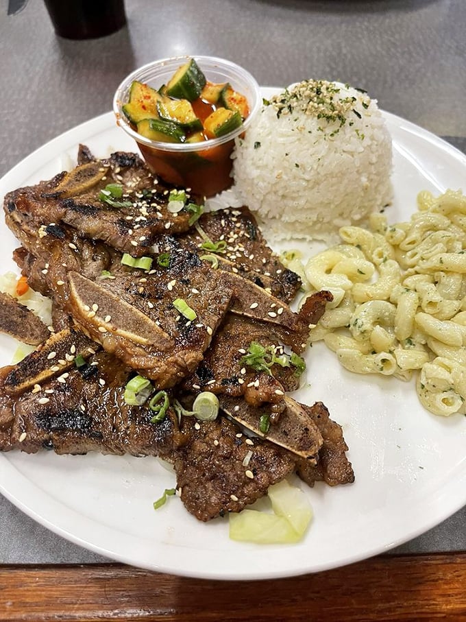 Kalbi short ribs arrive perfectly charred, glistening with sweet-savory marinade alongside creamy mac salad and a mound of fluffy rice.