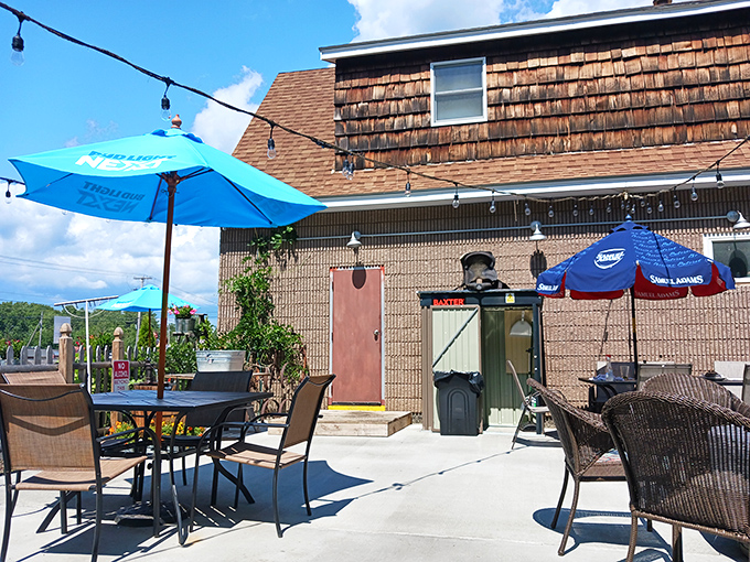 Summer perfection under blue umbrellas where the coastal breeze carries conversations and the promise of another perfect Maine afternoon.