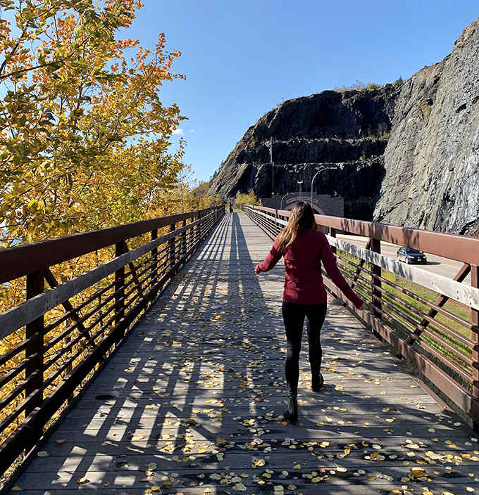 The elevated walkway offers hikers breathtaking views of both the tunnel below and Lake Superior beyond, a perfect vantage point for appreciating this engineering marvel.