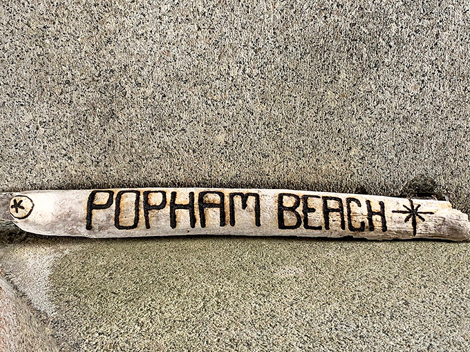 Beach artists transform driftwood into temporary coastal galleries &ndash; this piece spelling out the location of their sandy memories.