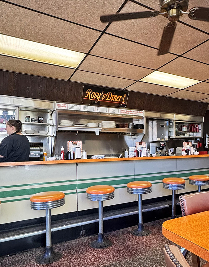 Classic diner counter seating invites solo diners and friendly conversation—these orange stools have supported generations of satisfied customers.