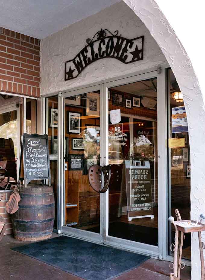 The welcoming entrance with its barrel planter and horseshoe decoration sets the tone for the down-home hospitality waiting inside.