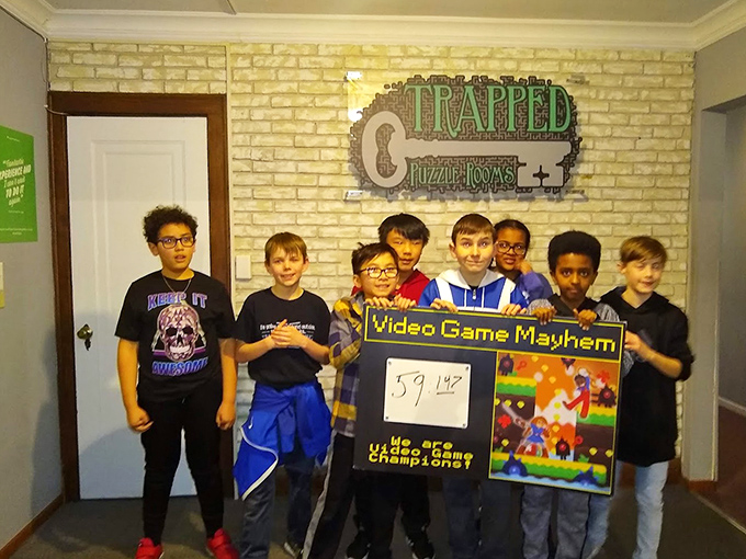 Young wizards-in-training celebrate conquering the "Video Game Mayhem" room, proving they're the true gaming champions with an impressive time.