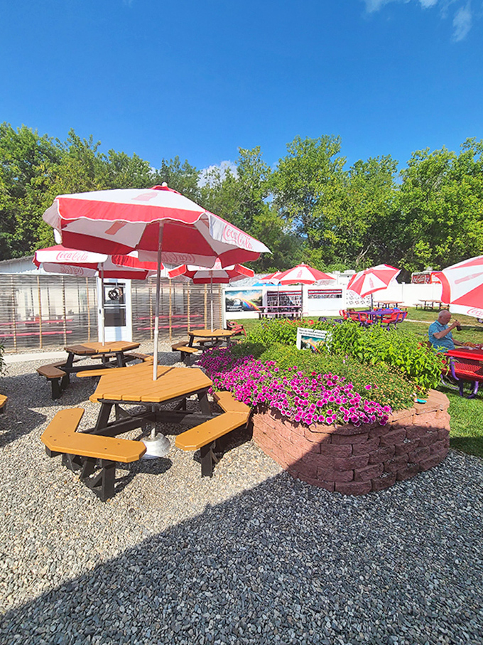 Red umbrellas dot this flower-framed oasis where summer breezes enhance the seafood experience.