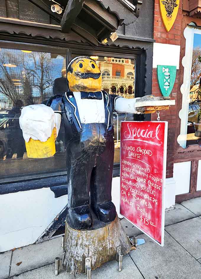 The wooden beer-toting gentleman stands guard outside, a quirky ambassador welcoming guests to this temple of cheese and camaraderie.
