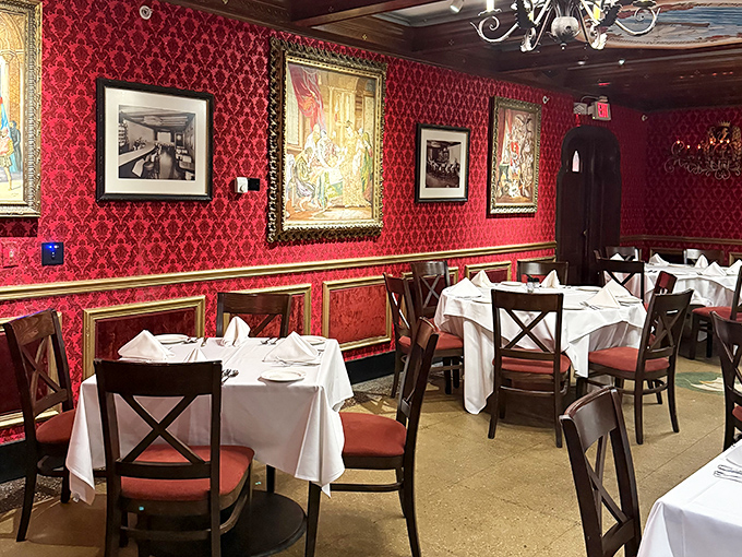 The red-walled dining room wraps guests in warmth, with gold accents and framed artwork creating old-world European charm.