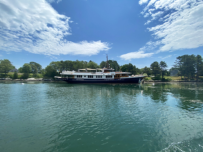 A stately yacht glides through the calm waters visible from Porter Preserve &ndash; adding a touch of maritime elegance to the natural scene.