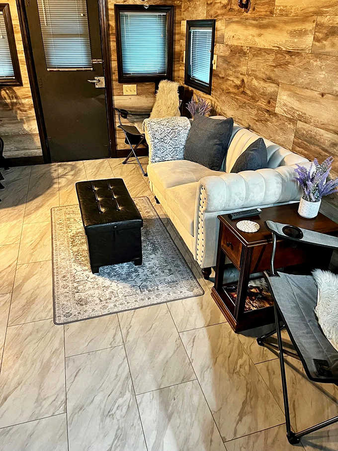Unwind on our plush sofa in the sunlit living space, complete with soft blankets and rustic wood-paneled walls for comfort.