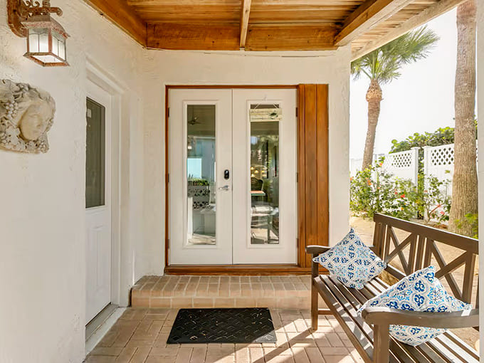 The covered entrance and welcoming porch set the tone for the coastal retreat that awaits just beyond those doors.